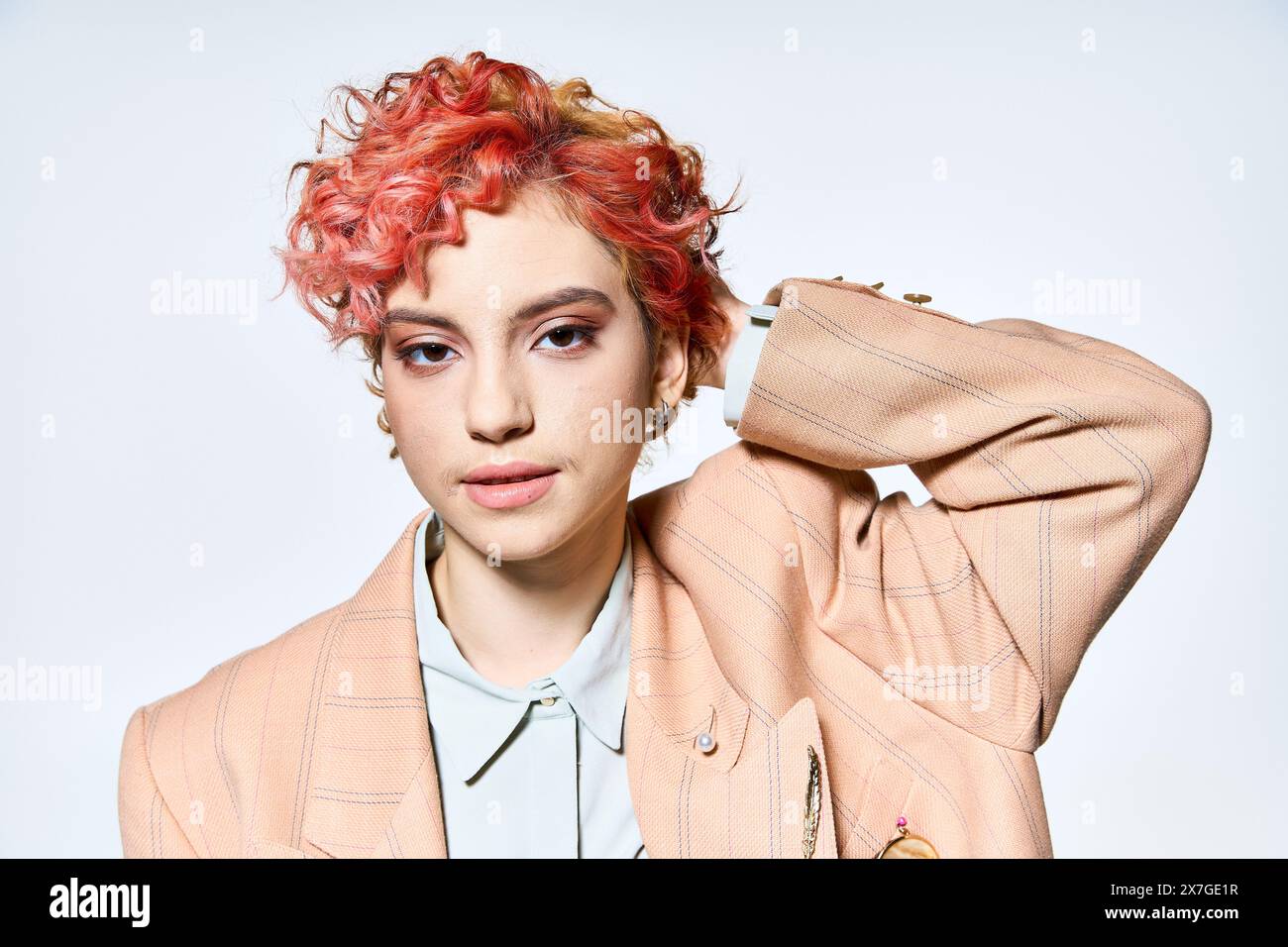 A vibrant woman with red hair strikes a pose for the camera Stock Photo ...