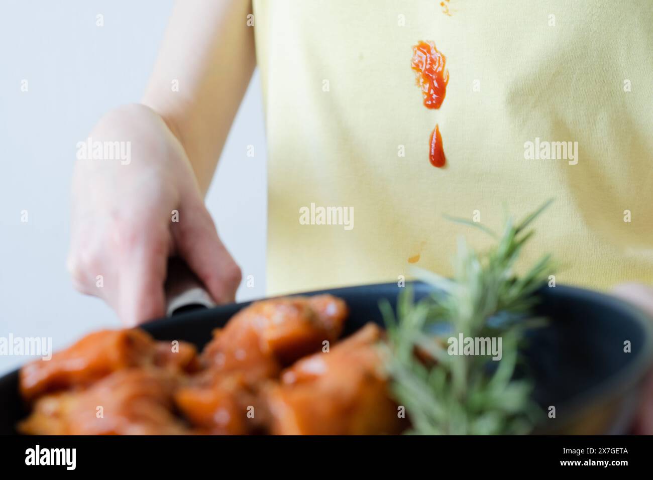 Spill tomato sauce on yellow clothes. Unrecognizable woman holding ...