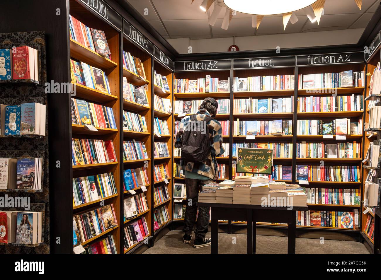 A male shopper browsing in the fiction section inside a Waterstones ...