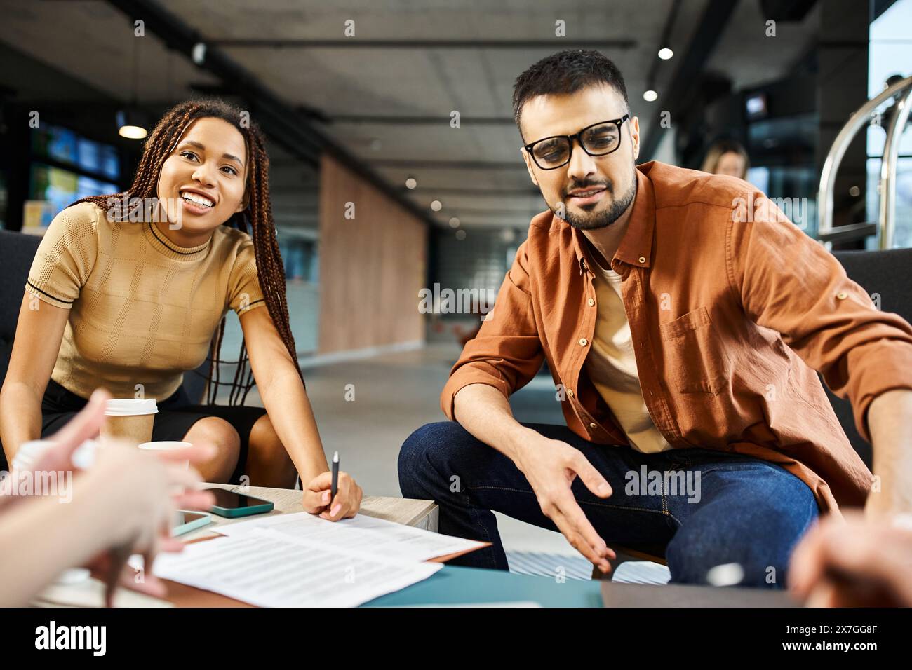 A diverse group of colleagues at a modern business meeting, discussing ideas and collaborating ...