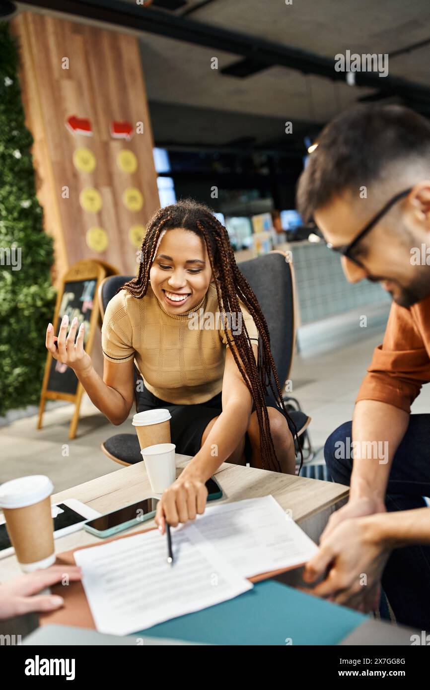 A diverse colleagues sit around a table, engaged in a brainstorming ...