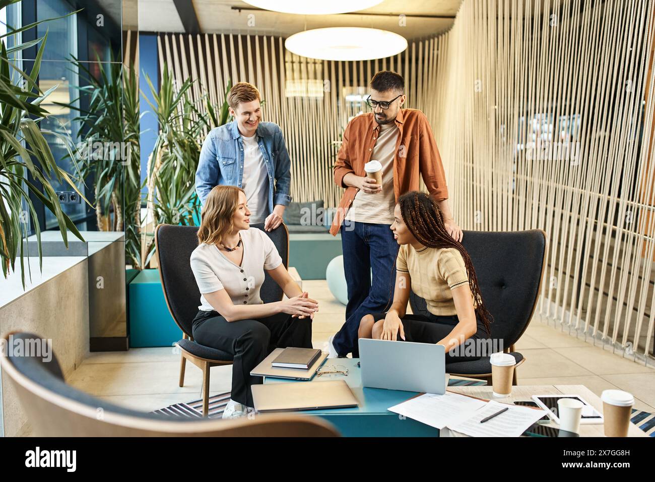 A diverse group of colleagues, part of a startup team, work together ...