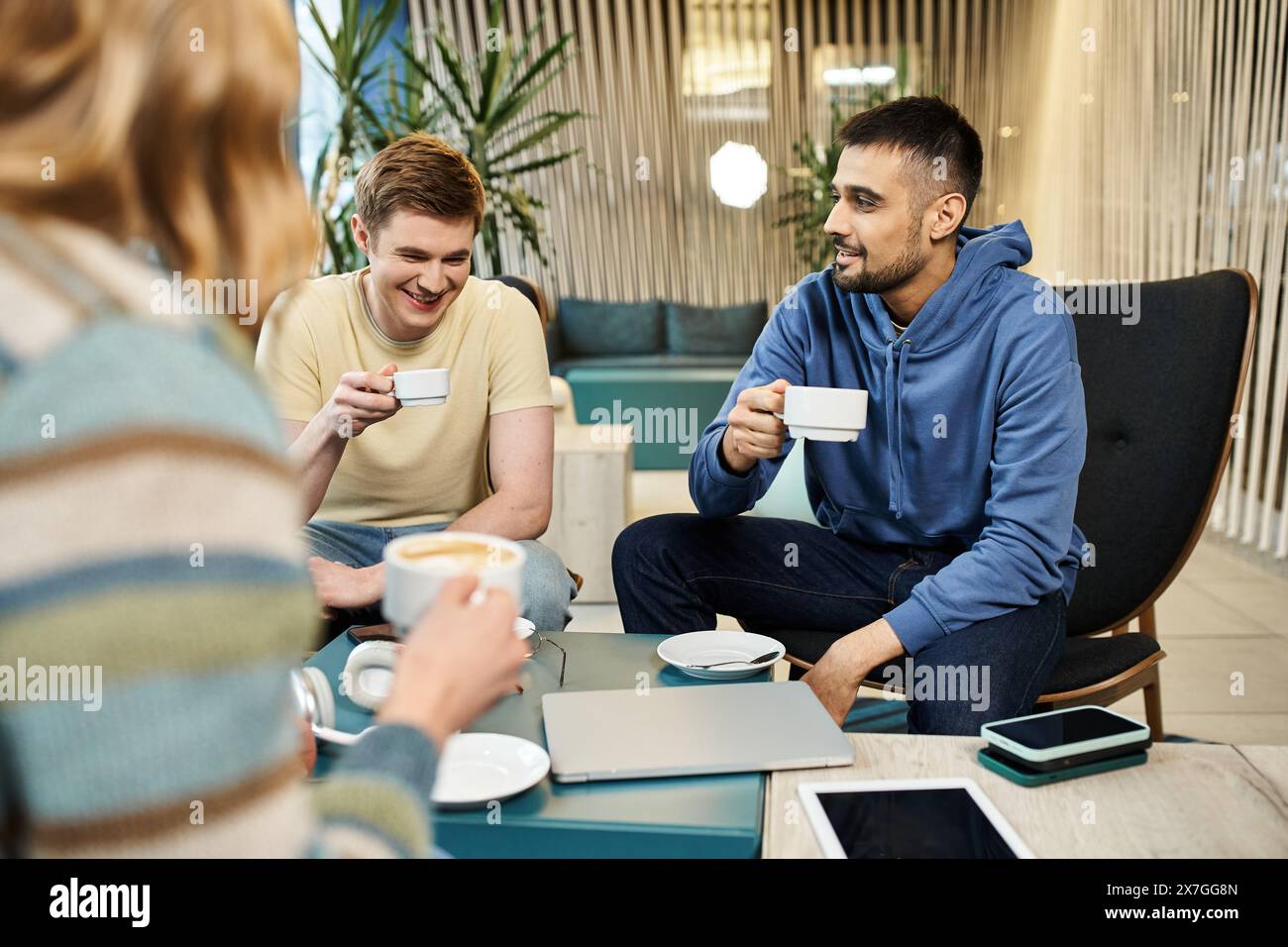 Colleagues from a startup team engage in a casual coffee break ...