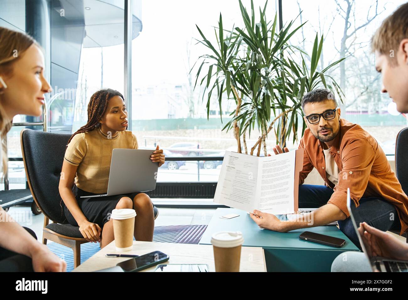 A diverse group of colleagues from a startup team work together around ...