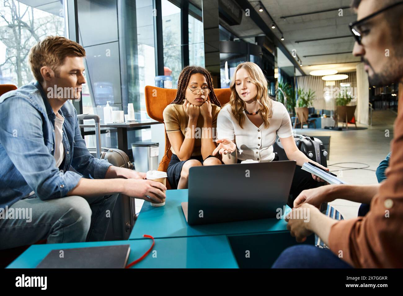 Multicultural business colleagues in casual attire work on laptop and ...