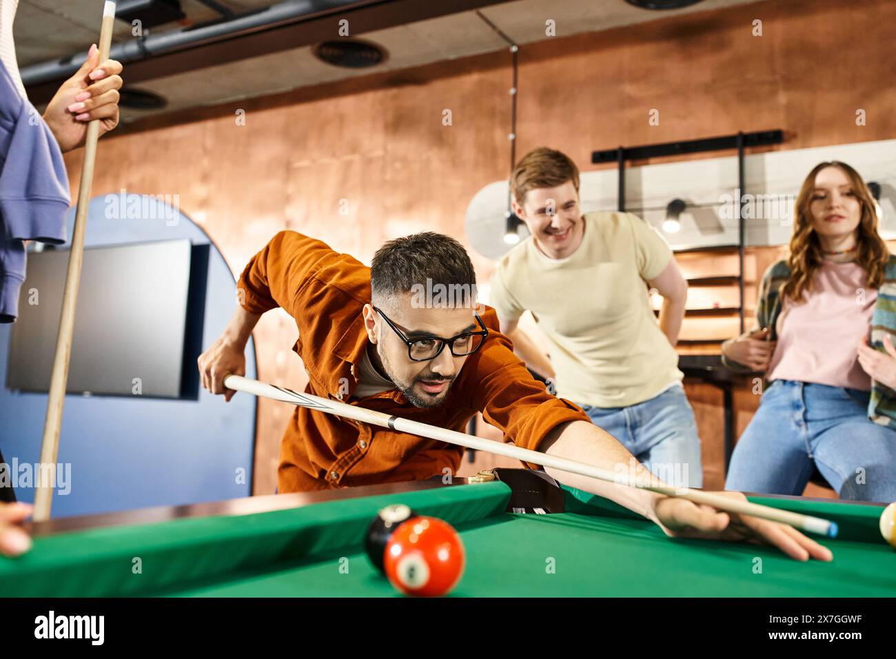 Successful startup team enjoying a game of pool in a stylish office ...