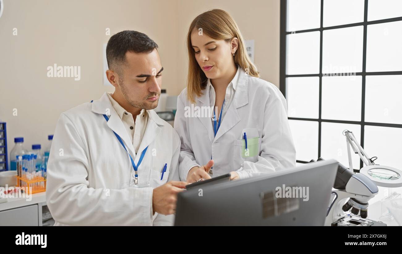Man and woman in lab coats working together in a bright laboratory ...