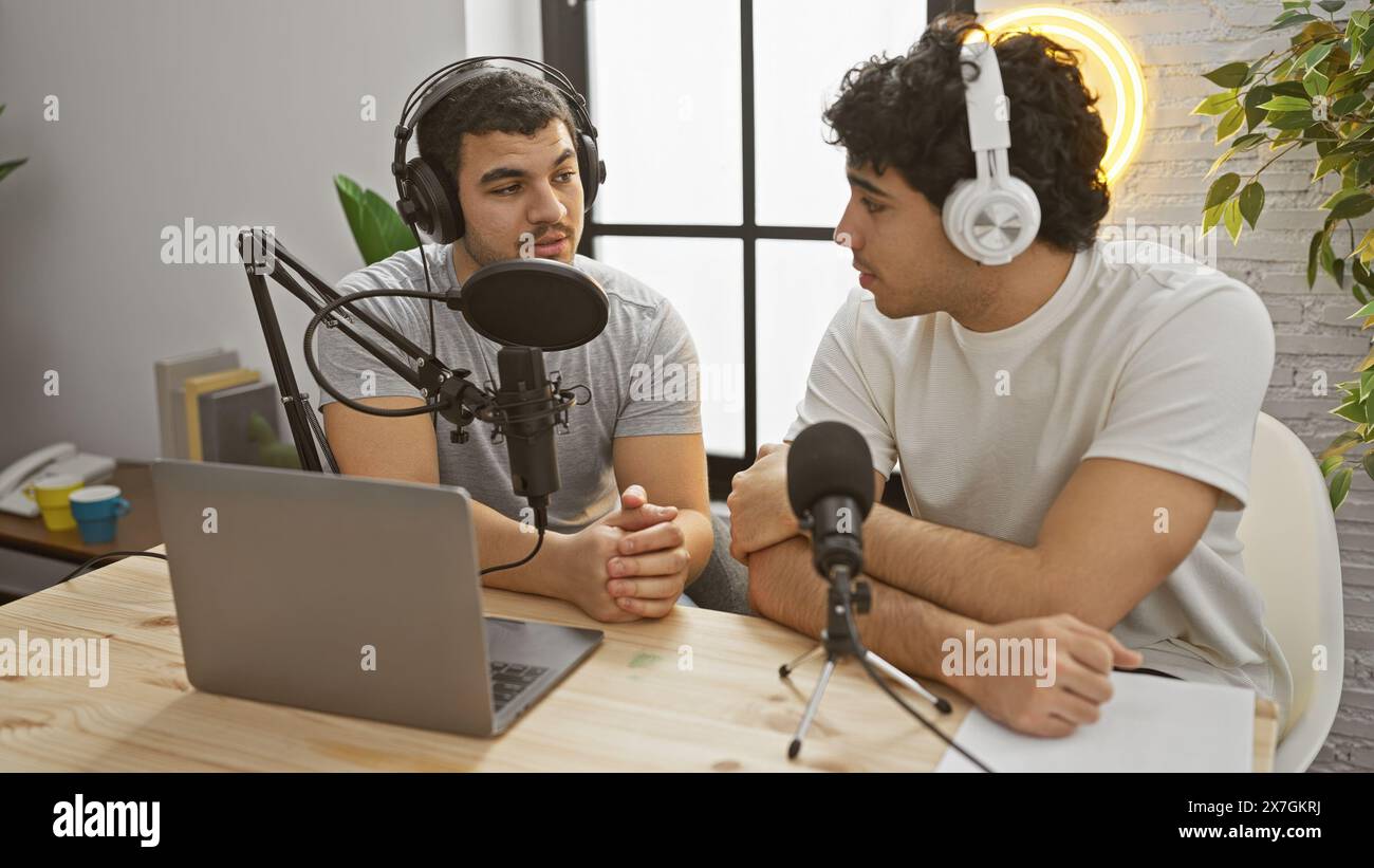Two men engaged in podcasting indoors, equipped with microphone ...