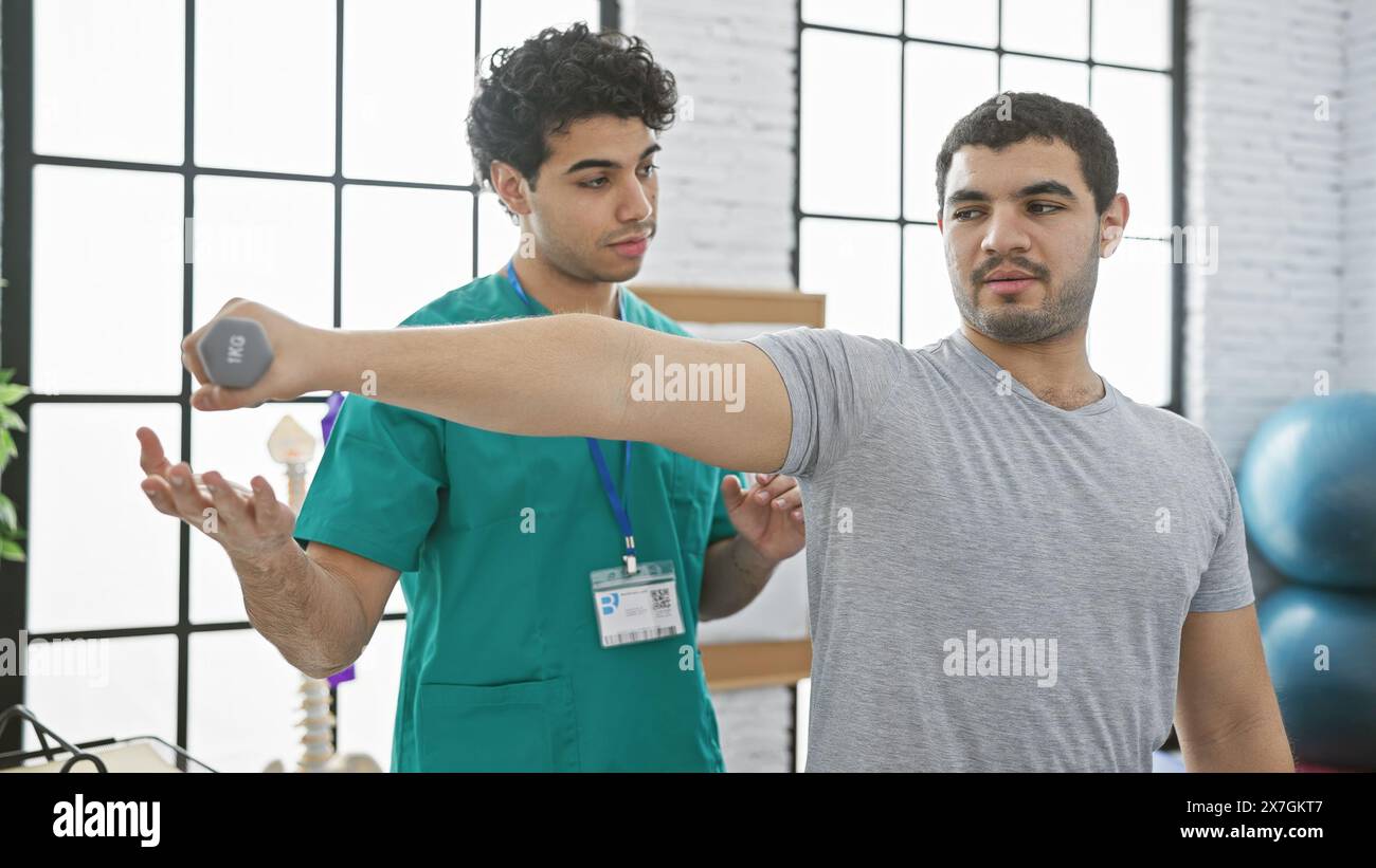 A male therapist guides a patient in a rehab exercise indoors, focusing ...