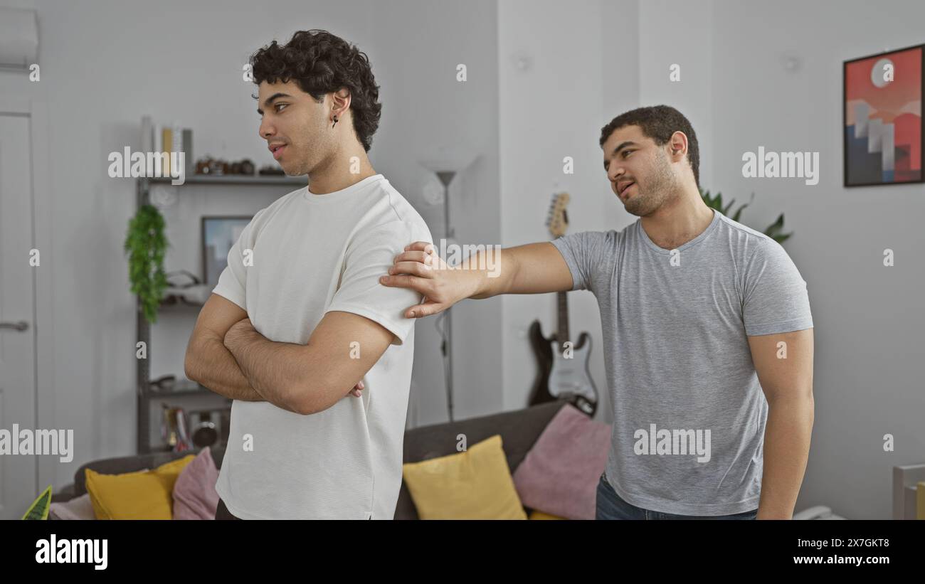 Two hispanic men reconcile in a modern living room, conveying ...
