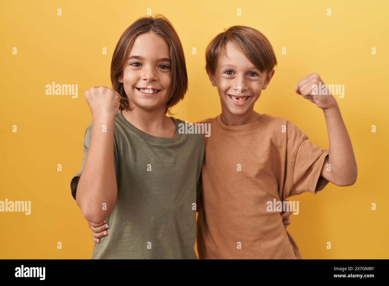Two excited boys cheering triumphantly, raising arms in victory ...