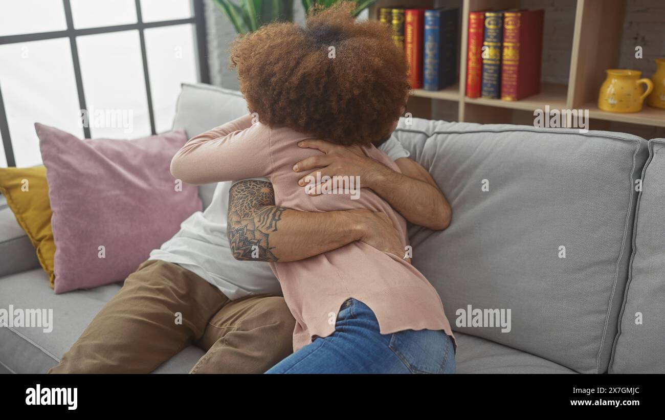 A man and woman embrace lovingly on a cozy sofa in a well-lit modern ...