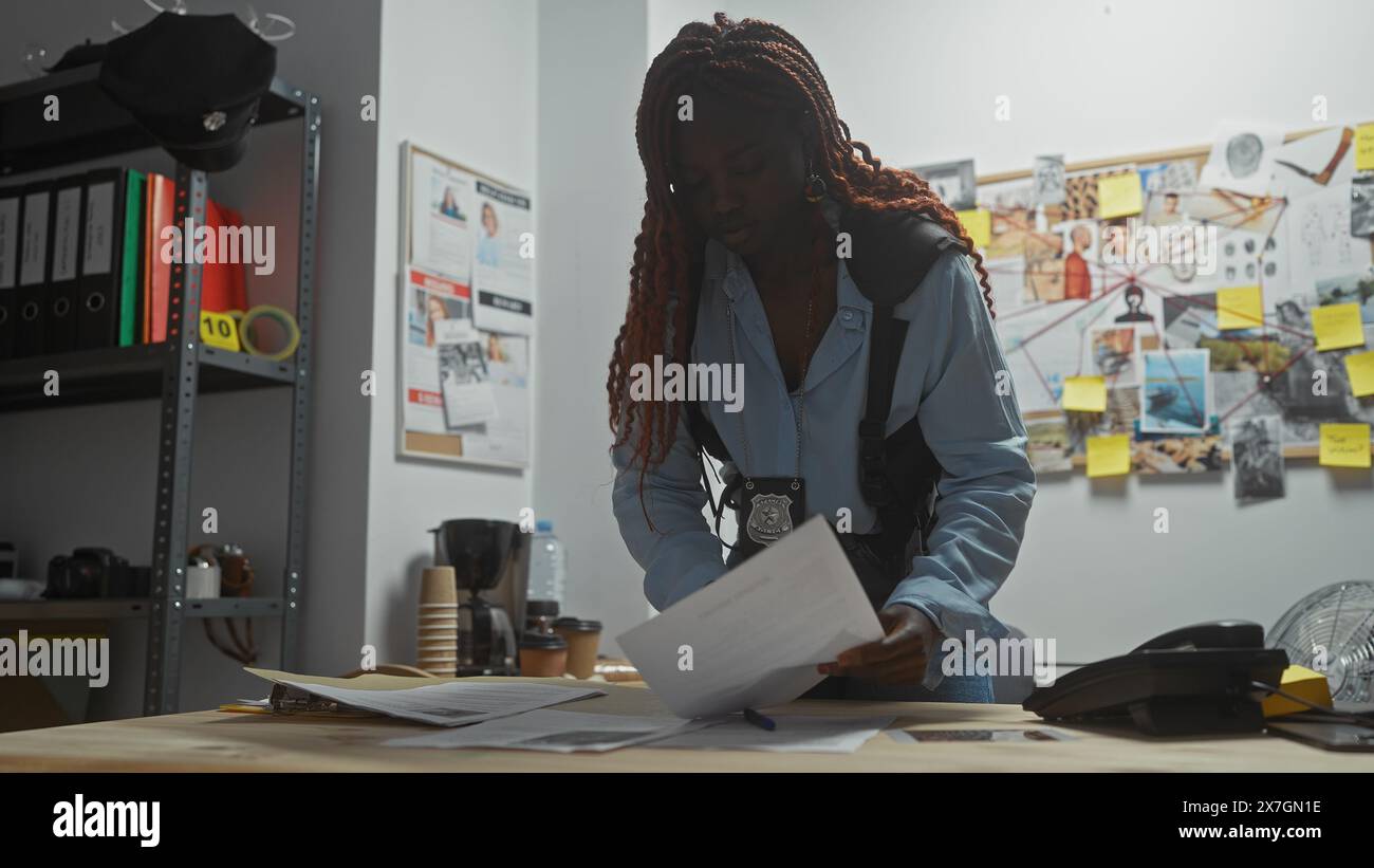 A focused african american woman detective analyzes documents in a ...