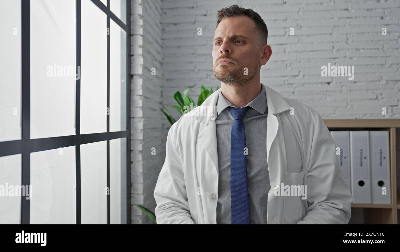 Professional man in medical lab coat standing thoughtfully in a modern ...