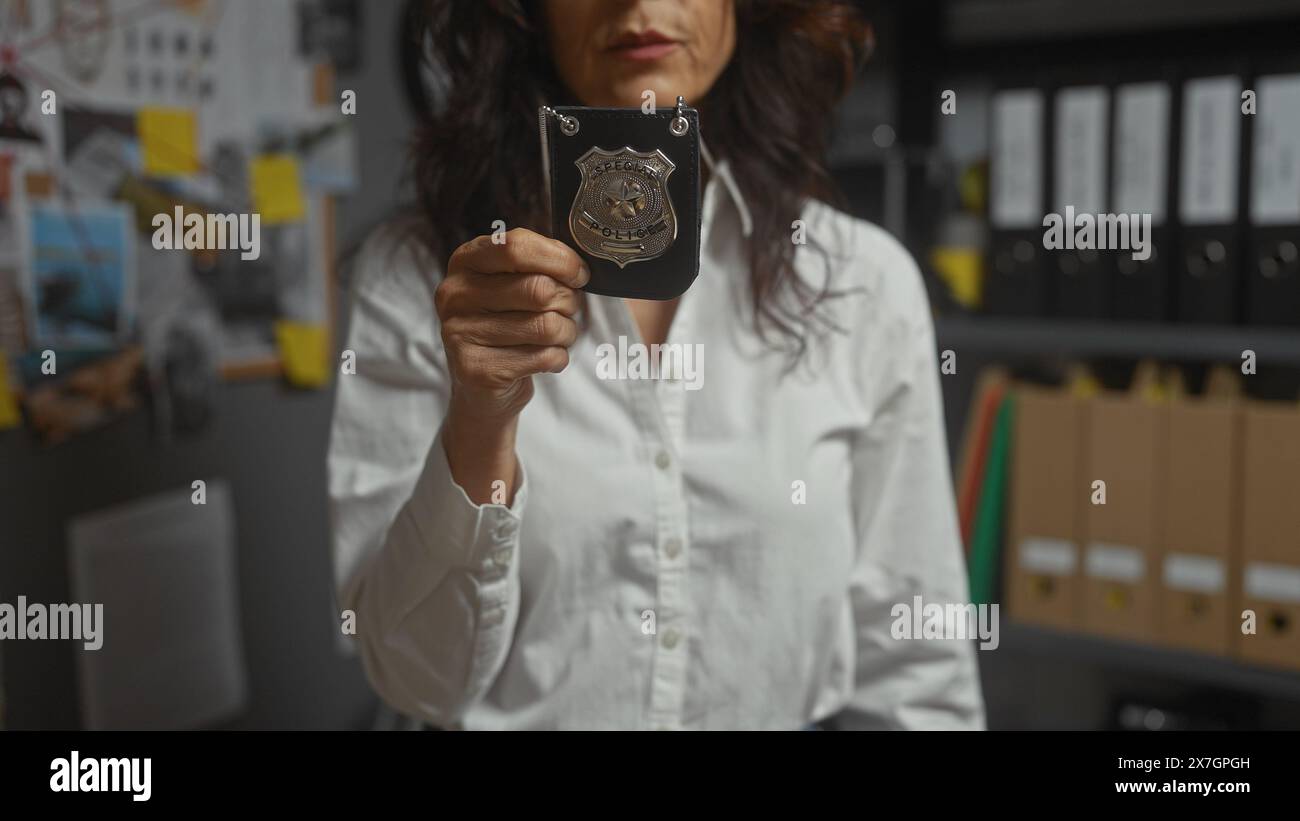A woman detective displaying her badge in a police station office with ...