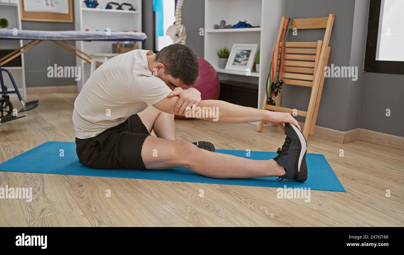 Hispanic man stretching in a rehabilitation clinic's therapy room Stock Photo - Alamy