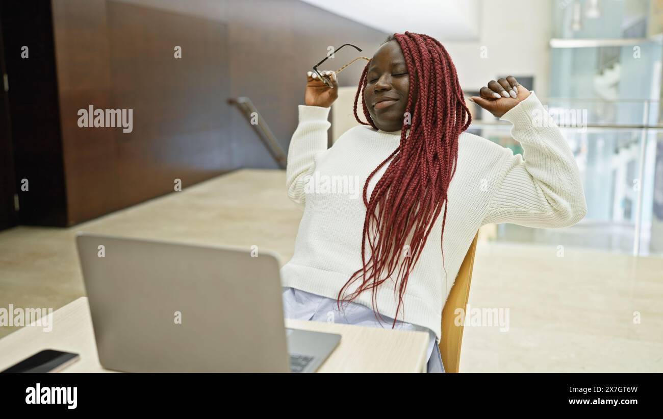 Relaxed african american woman with braids enjoying a break at her ...