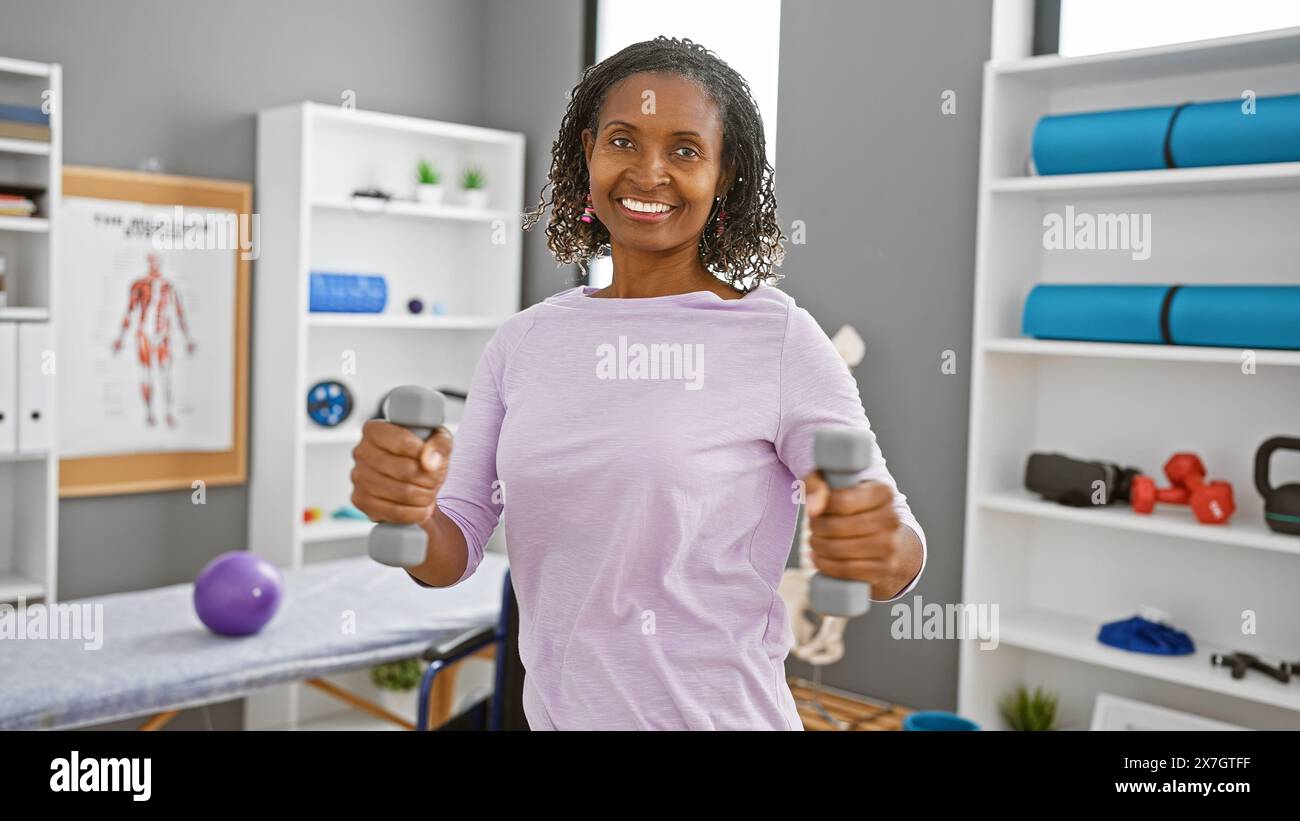 African american woman exercising with dumbbells in a physical therapy ...