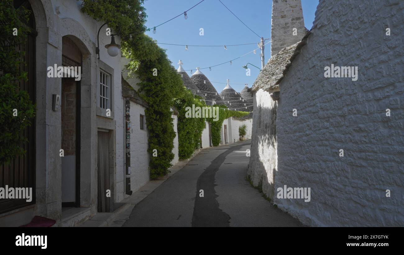 A serene alley in alberobello, italy features charming white stone ...