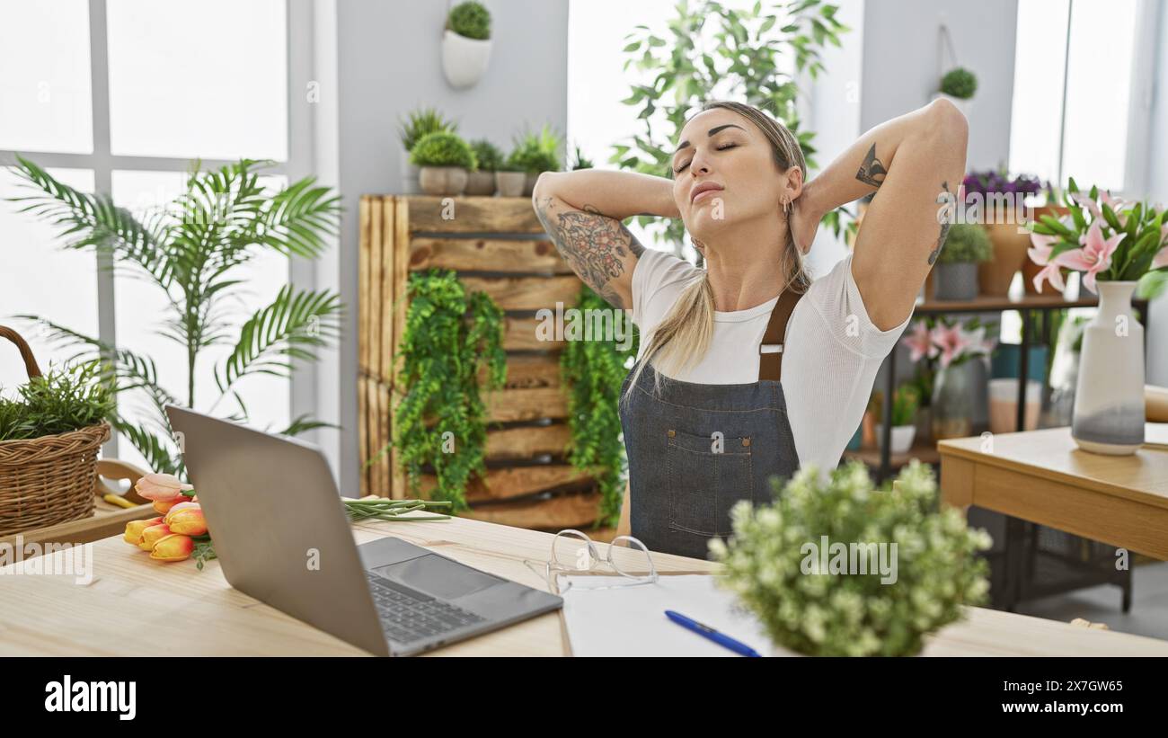 Relaxed woman florist stretching in a green plant-filled flower shop ...