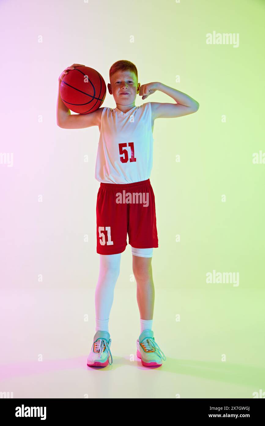 Full-length image of teen boy, basketball player in uniform posing with ...