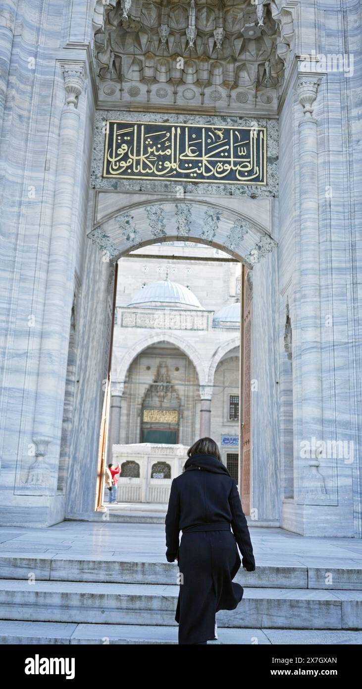 A woman in black clothing approaches the grand entrance of the ...