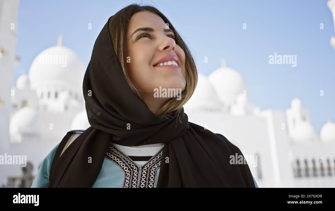 Smiling woman in hijab with sheikh zayed grand mosque backdrop ...