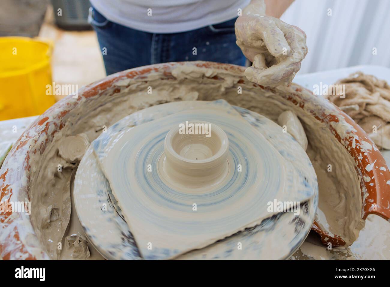 Creating clay dishes on potter wheel, a potter hand sculpts soft clay ...