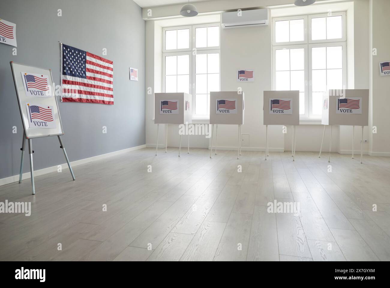 Empty polling station with white voting booths and American flag ...