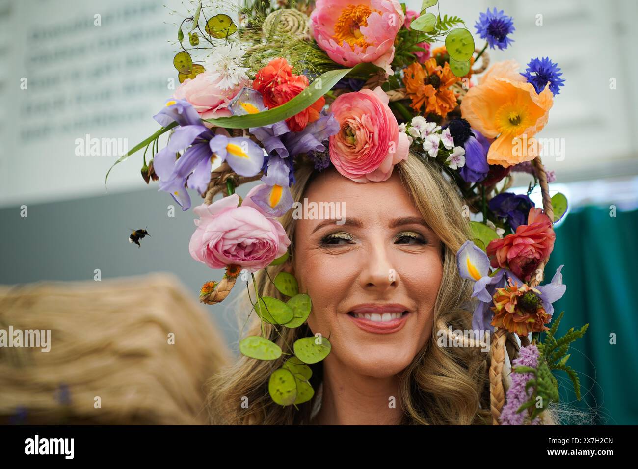 A Bee is attracted to a model wearing floral headwear created by Acacia ...