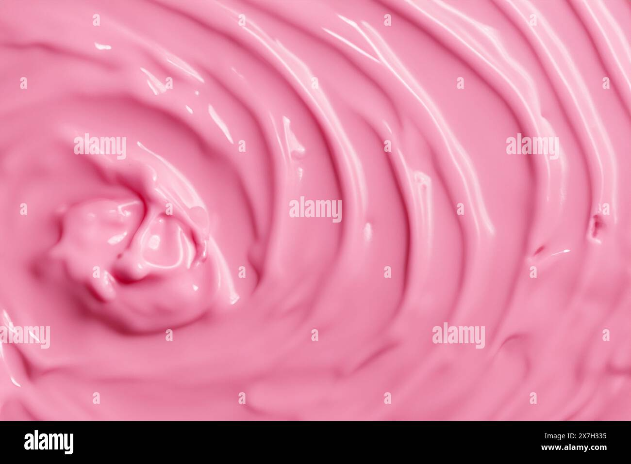 A close-up view of a swirl of vibrant pink yogurt. The soft, creamy ...