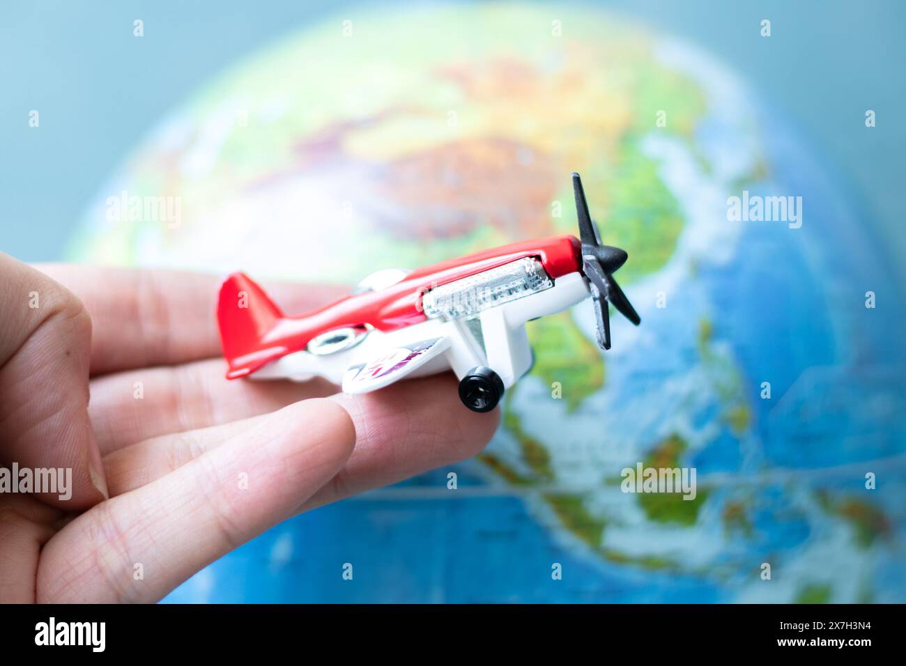 Aviation idea concept. Toy airplane in front of world model background ...