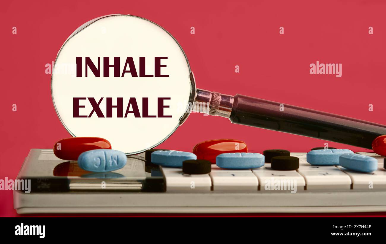 INHALE EXHALE written words through a magnifying glass on a calculator ...