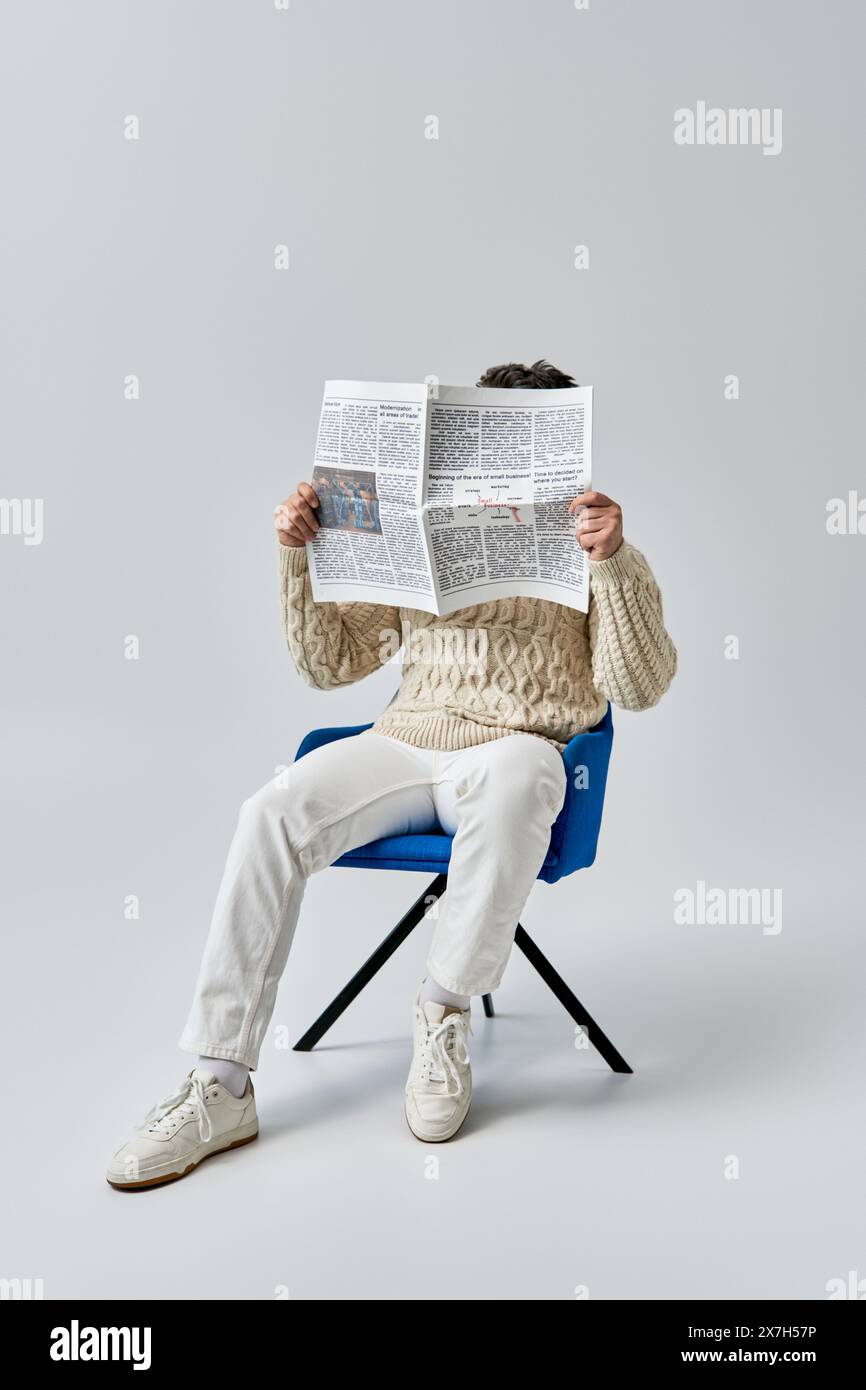 Man sitting on a chair reading a newspaper hi-res stock photography and ...