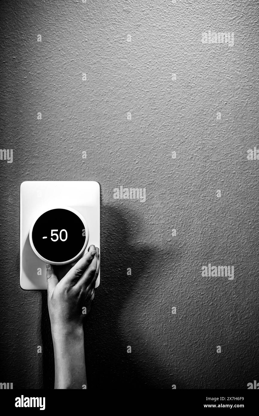 Small child hand reaching up to change the temperature on a thermostat ...