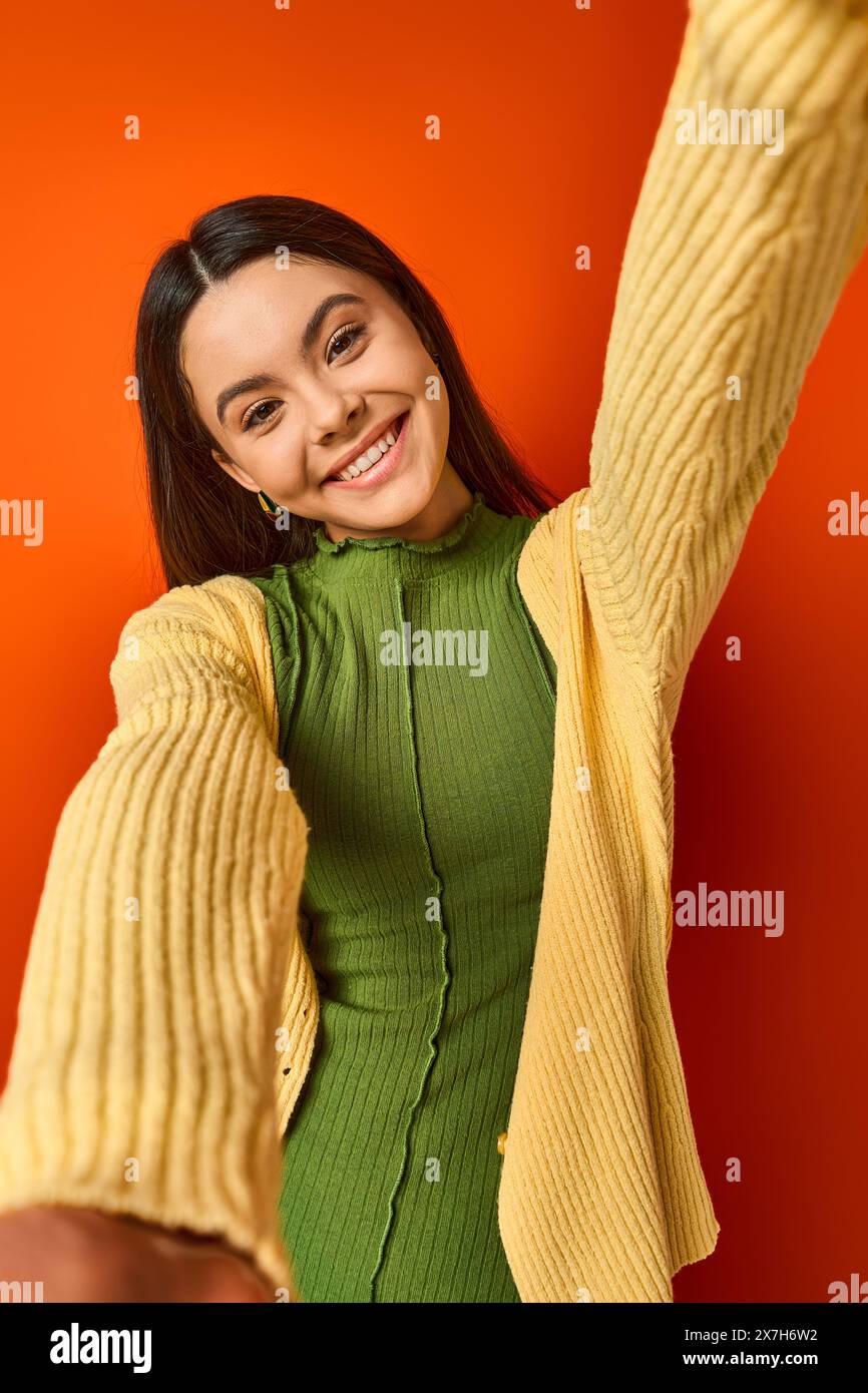 A brunette teenage girl wearing a green dress and a yellow cardigan ...