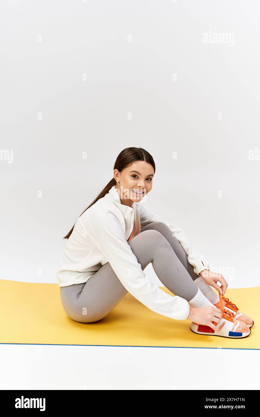 A serene girl with crossed legs on the mat, expressing calmness and ...