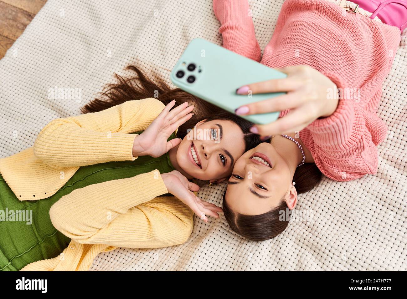Two young women dressed casually, sharing a moment of laughter as they ...