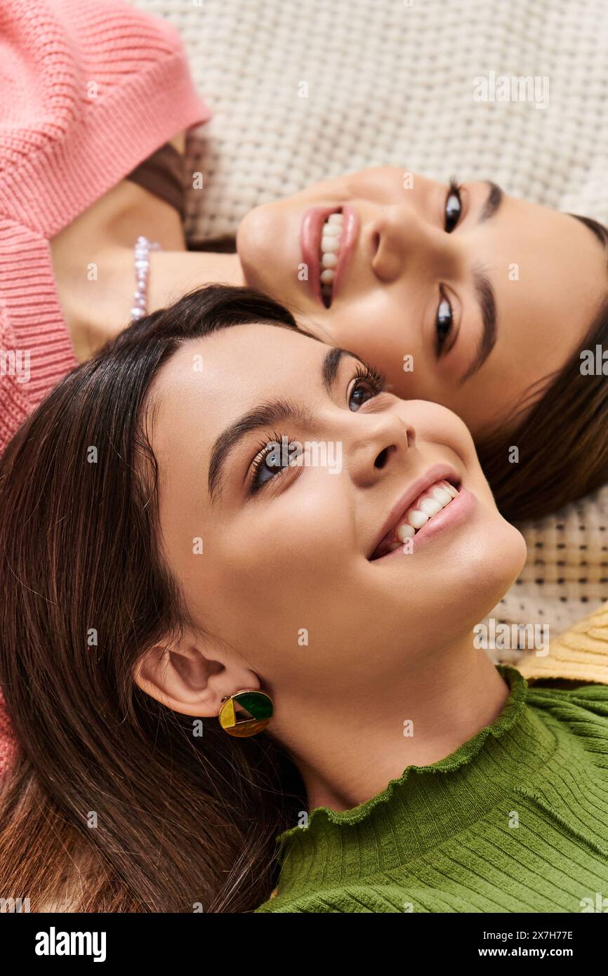 Two pretty teenage girls in casual attire embrace each other while ...