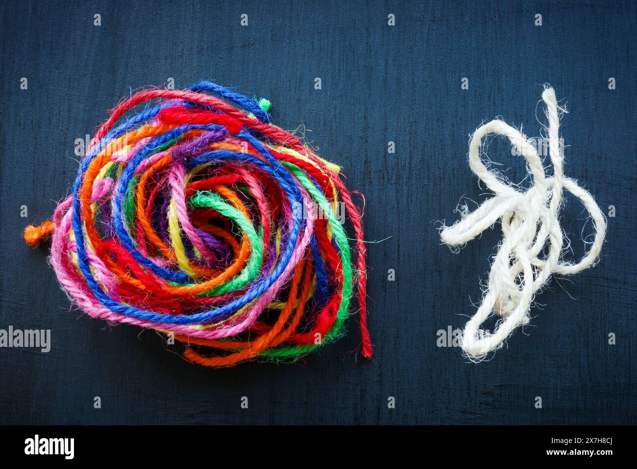 A ball of colored threads and a regular one next to it as a symbol of ...