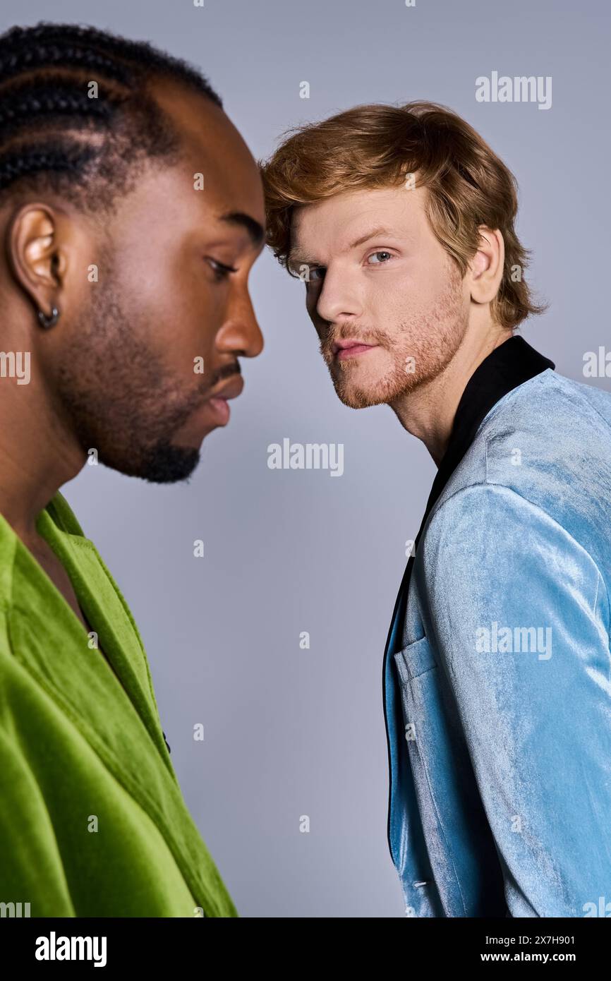 Two multicultural men in dapper attire standing together, making eye ...