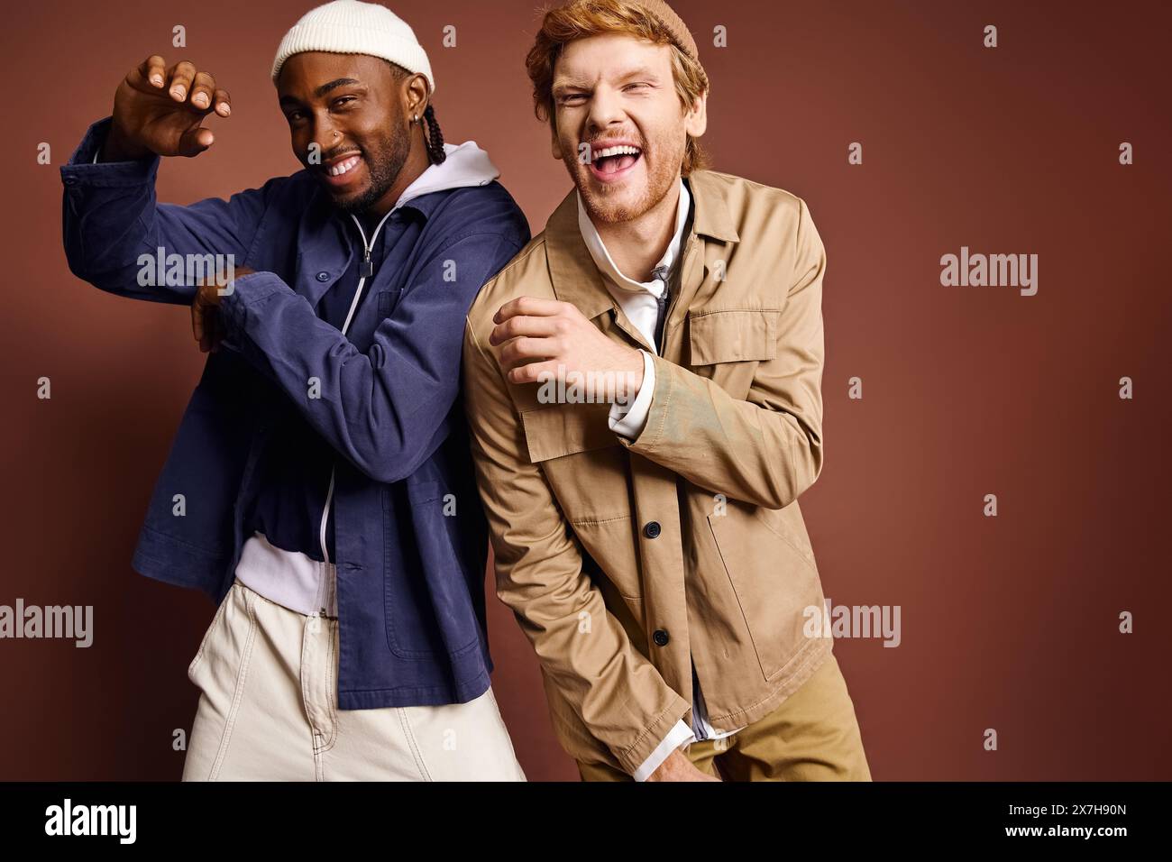 Two stylish multicultural men pose in front of a brown background Stock ...