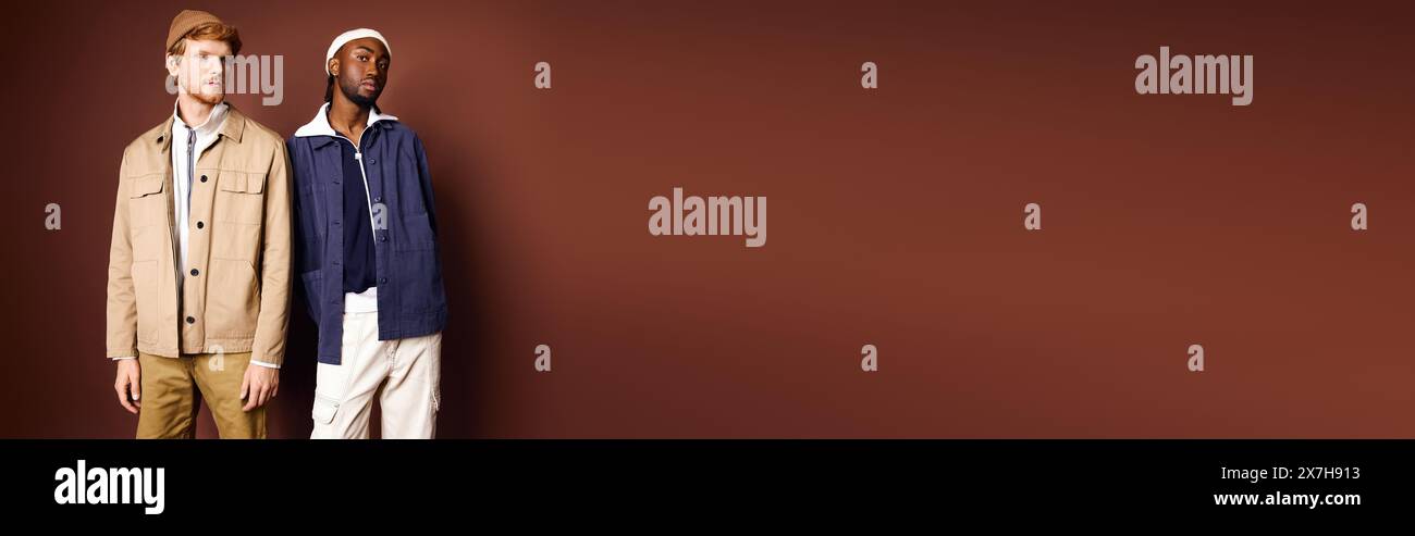 Two good-looking men with stylish attire pose together in front of a ...