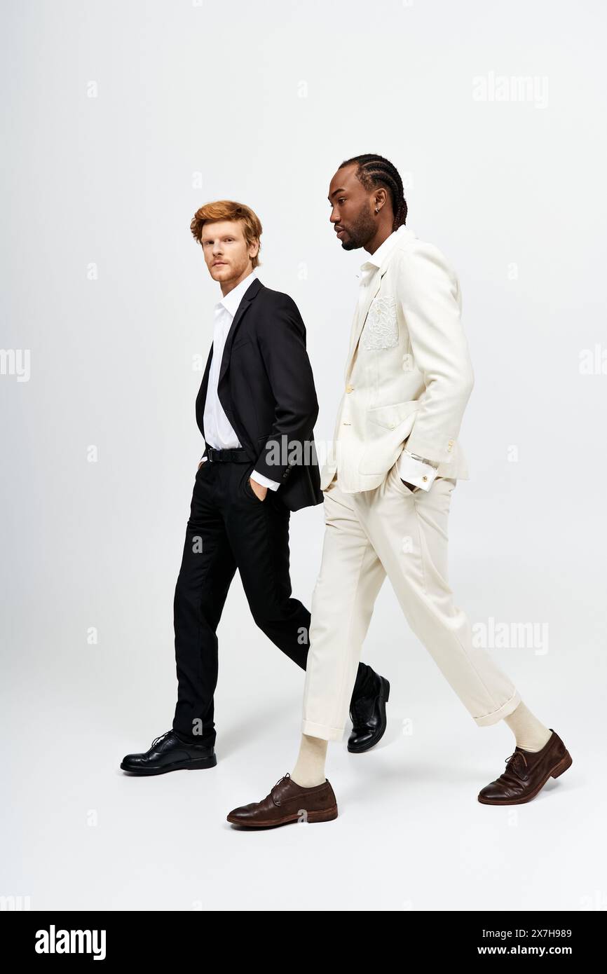 Two handsome multicultural men in stylish suits walking side by side ...