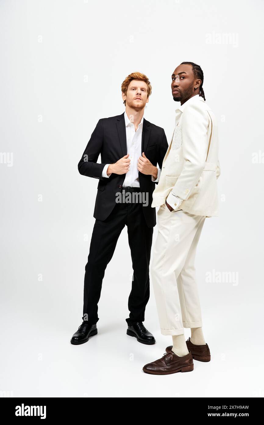 Two stylish men in suits stand shoulder to shoulder Stock Photo - Alamy