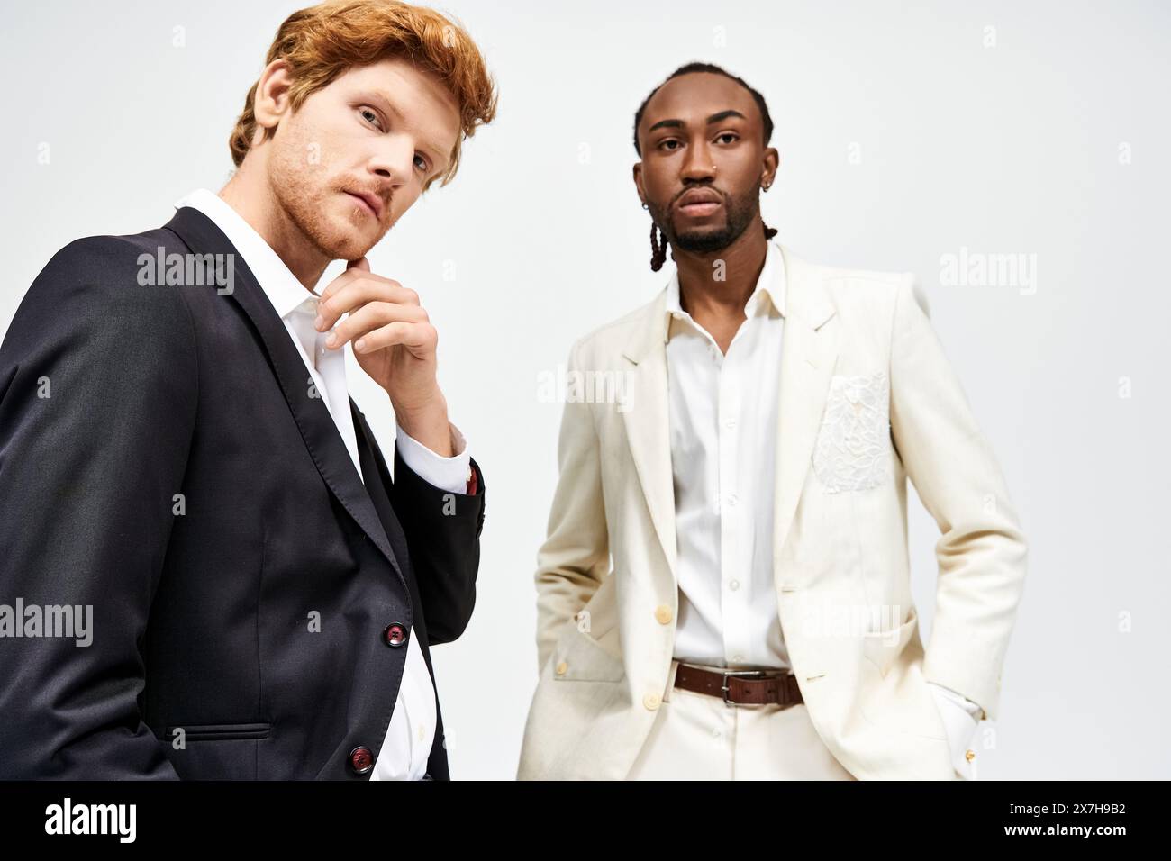 Two handsome multicultural men in stylish suits stand convincingly ...