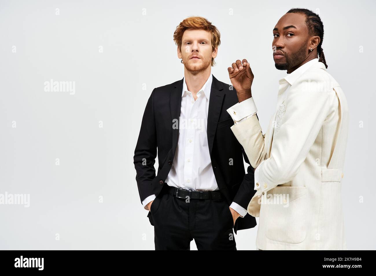 Two handsome, multicultural men in elegant attire stand together ...