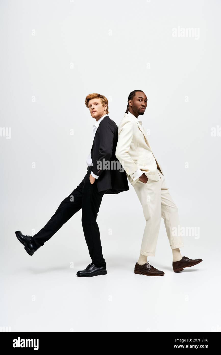 Two handsome multicultural men in suits posing side by side in a ...