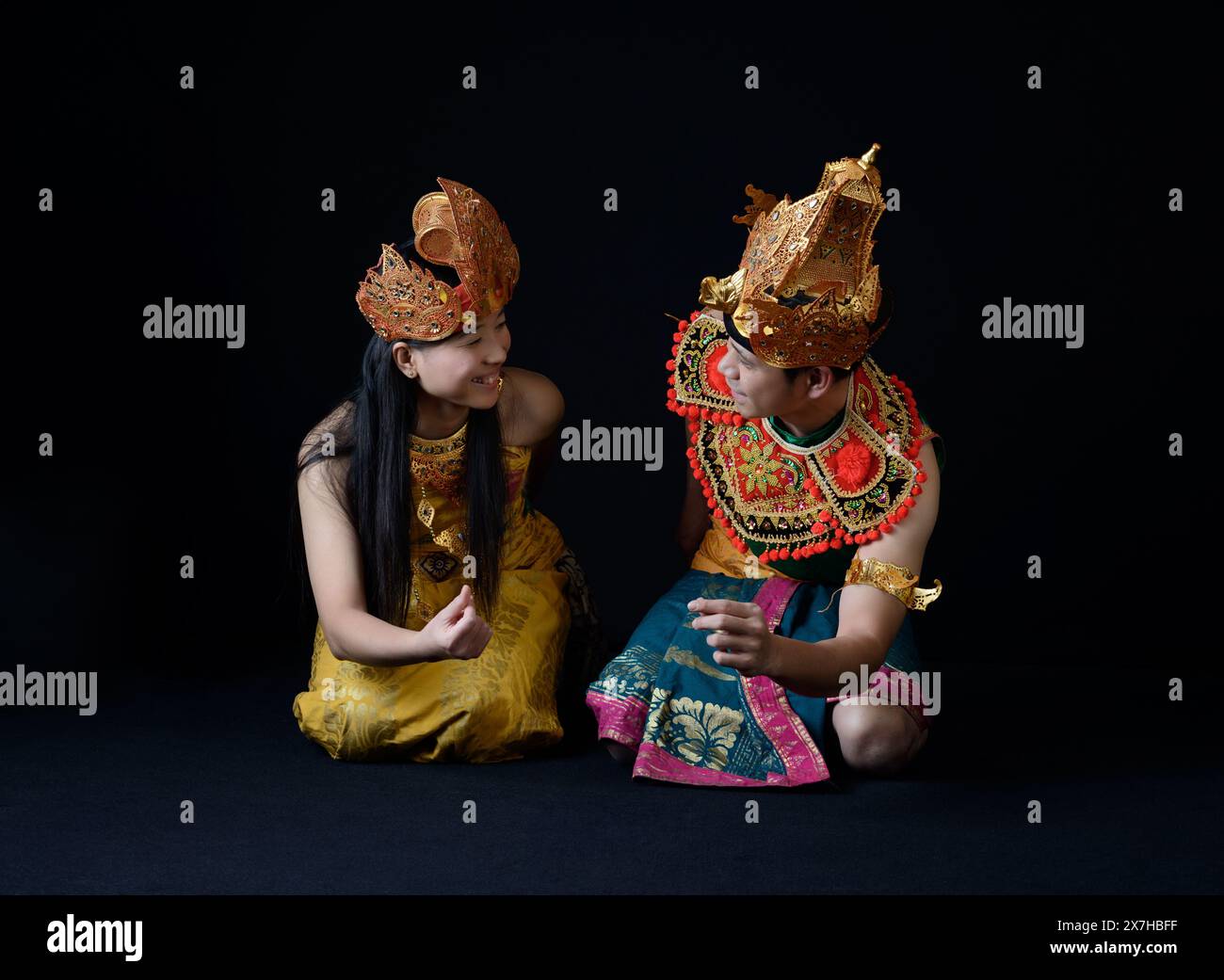 Indonesian man and woman wearing traditional dance costumes, seated and ...