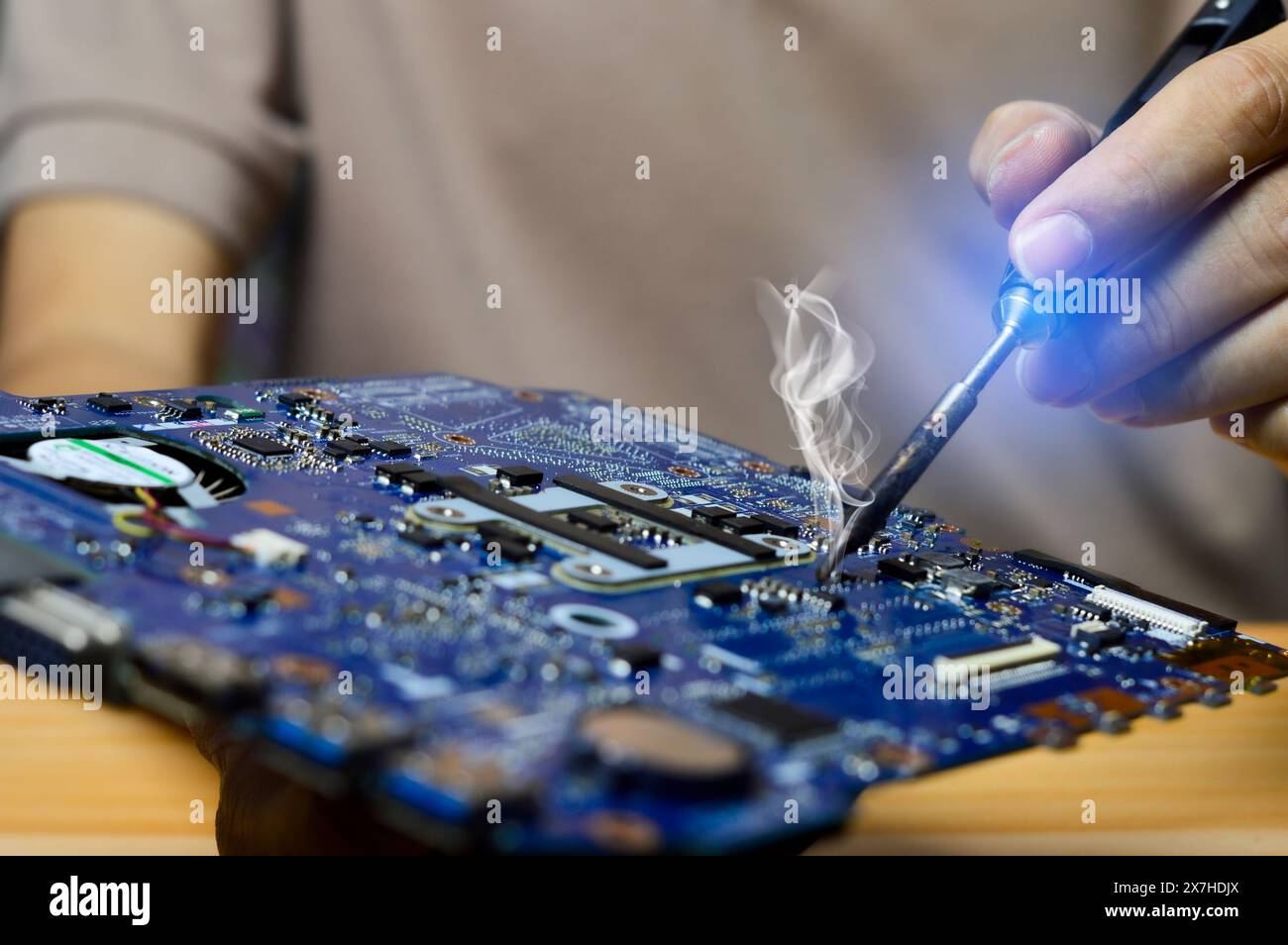 Technician concept repairing computer motherboard, soldering circuits ...